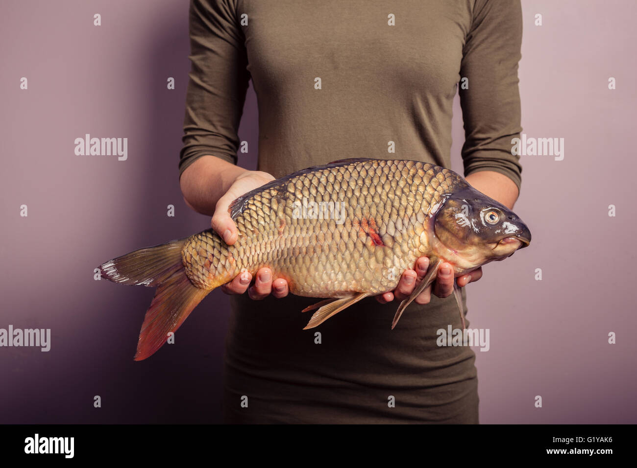 A young woman is holding carp Stock Photo - Alamy