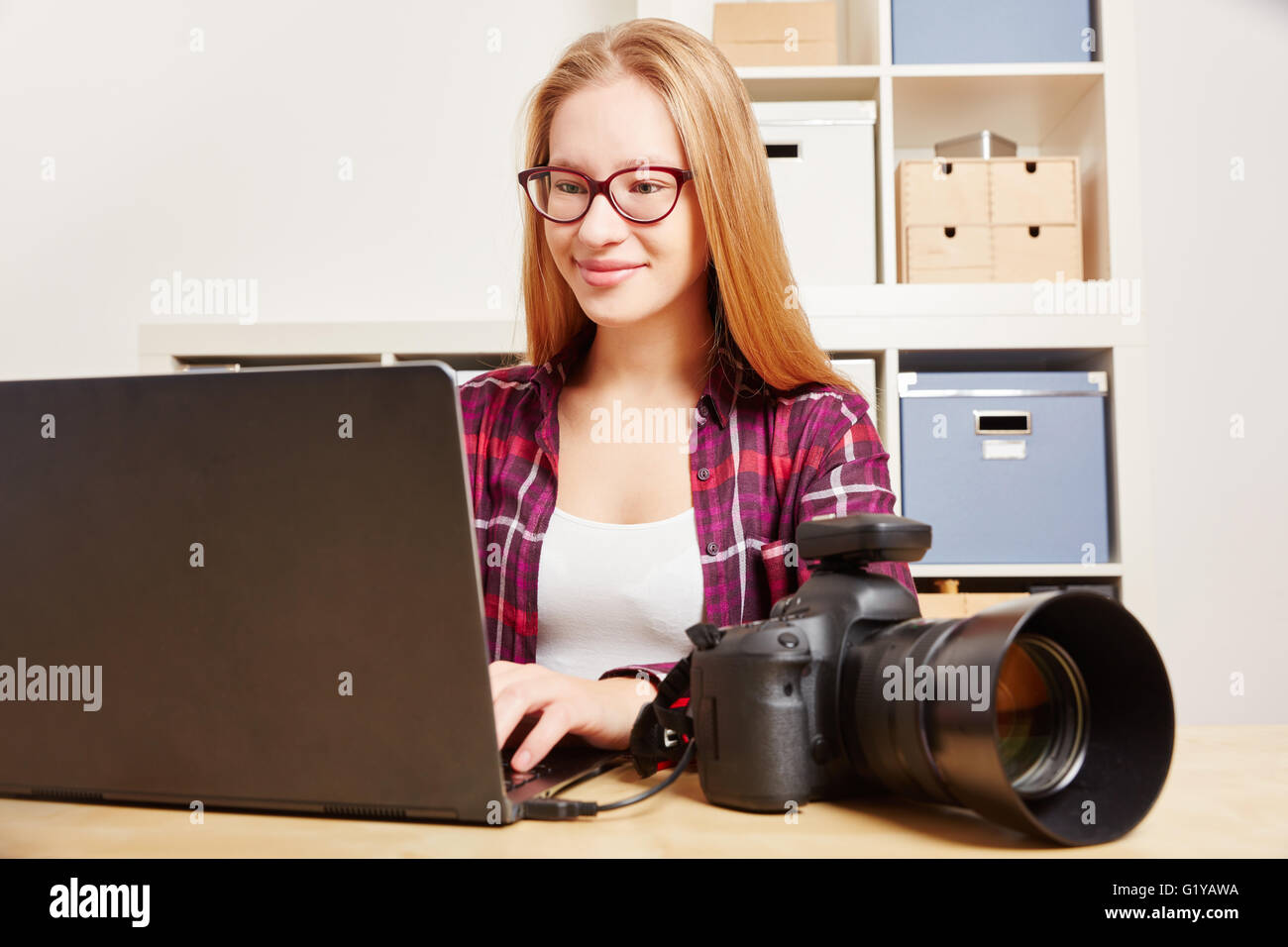 Photographer with DSLR Camera and Laptop in her office Stock Photo - Alamy