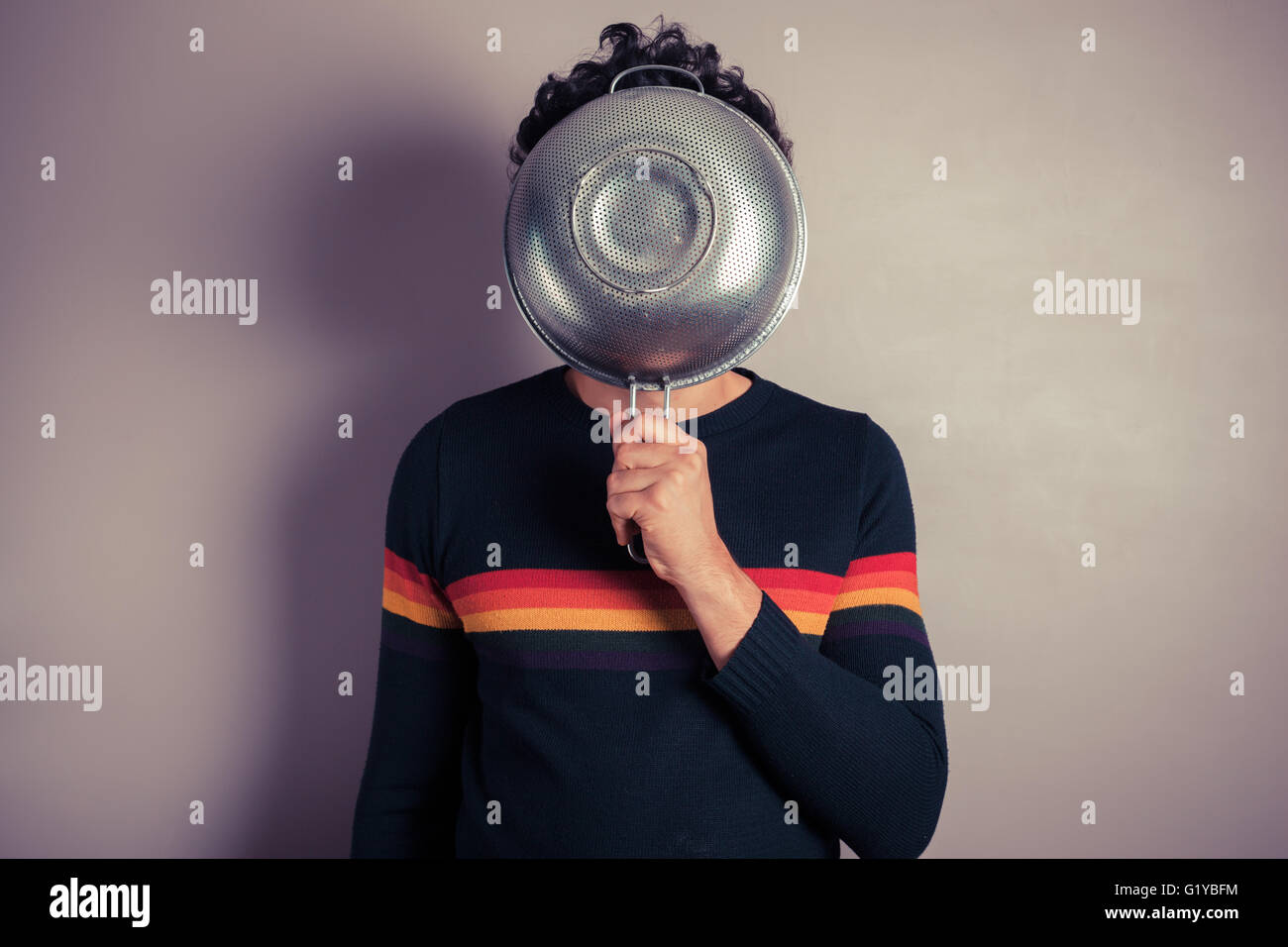 A young man is hiding his face behind a colander Stock Photo - Alamy