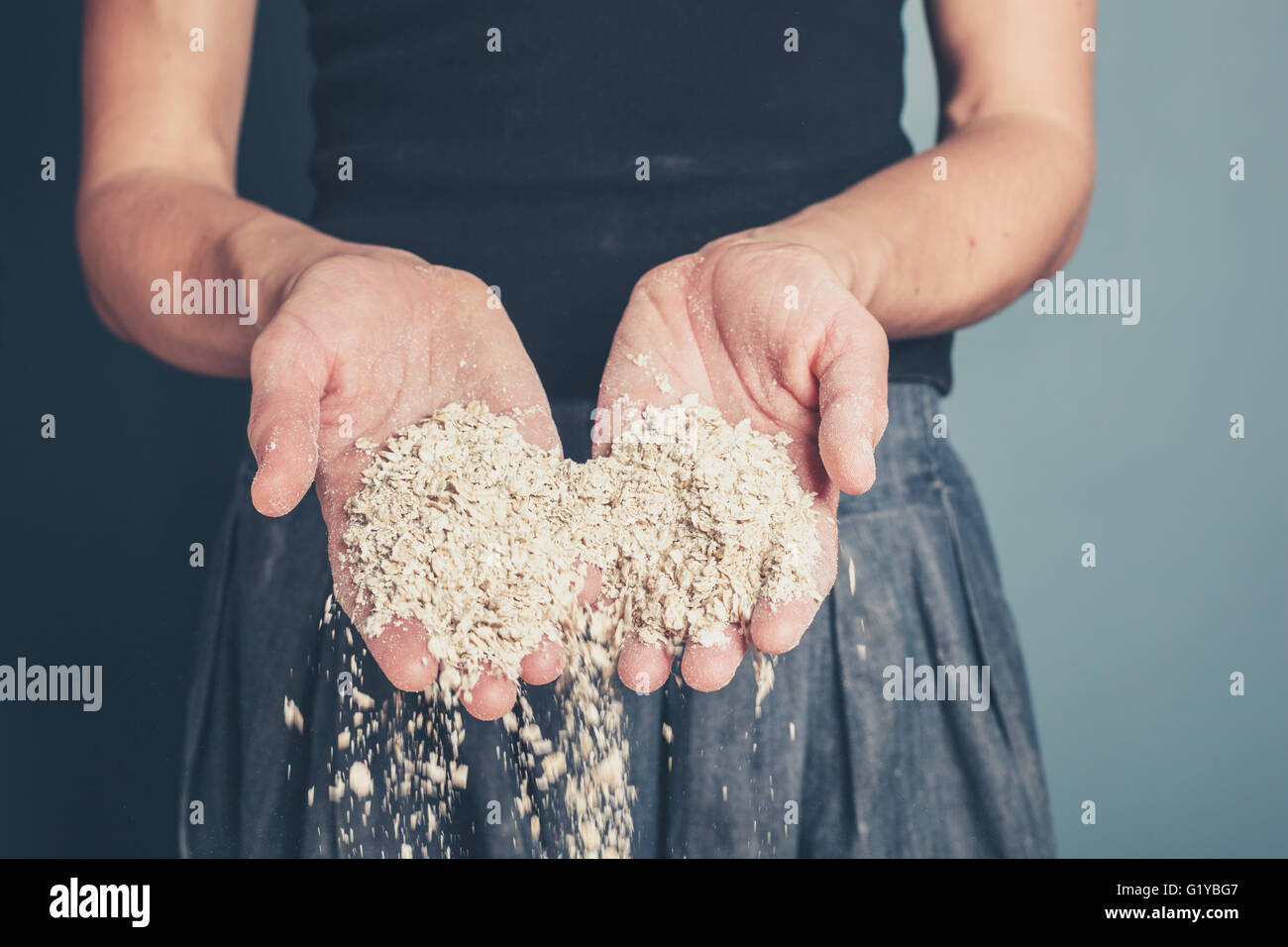 A young woman is standing with a handful of oats Stock Photo - Alamy