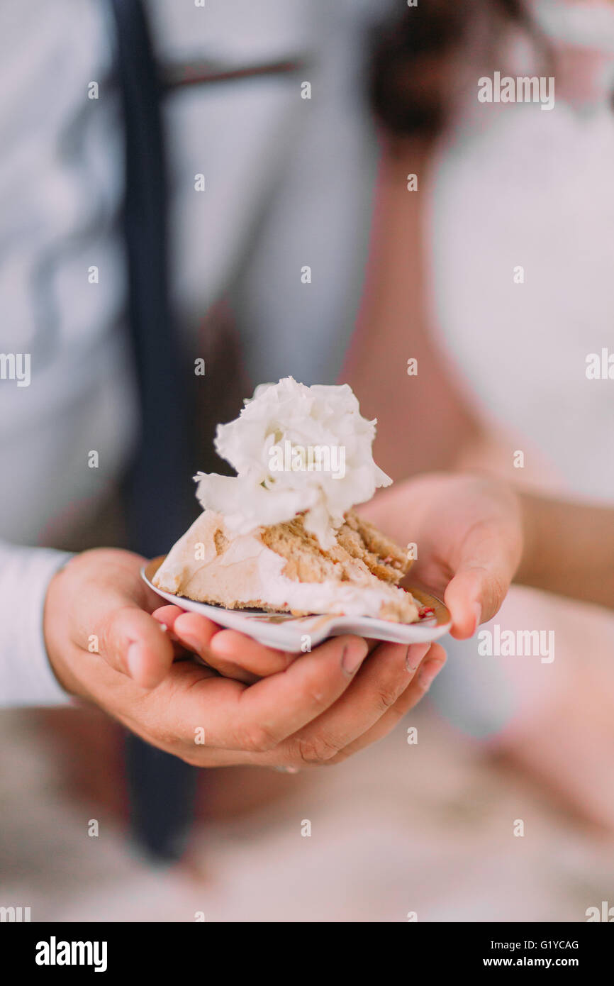 Bride and groom holding piece of their wedding cake, close-up Stock ...