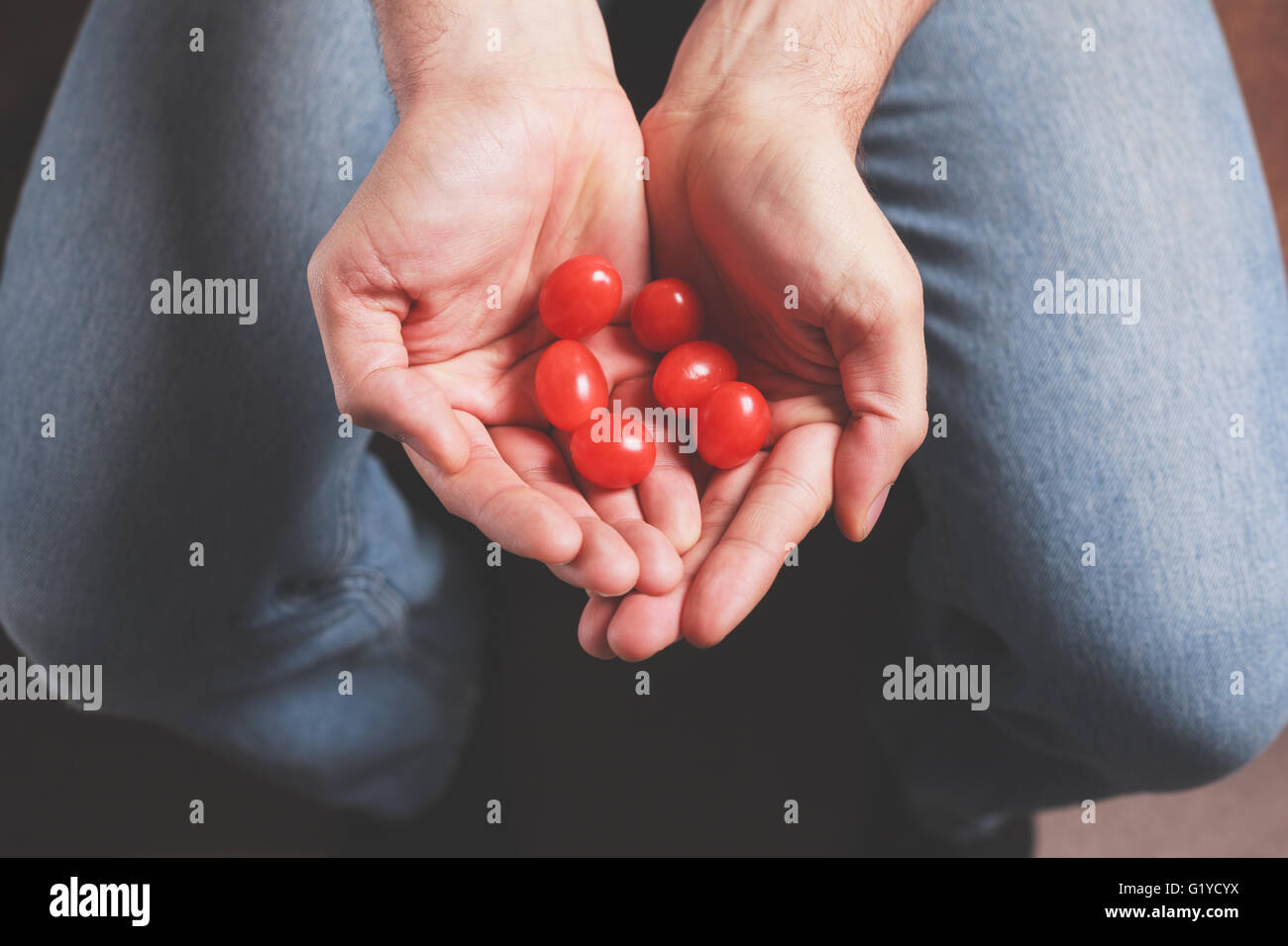 A man is holding a handful of tomatoes Stock Photo - Alamy