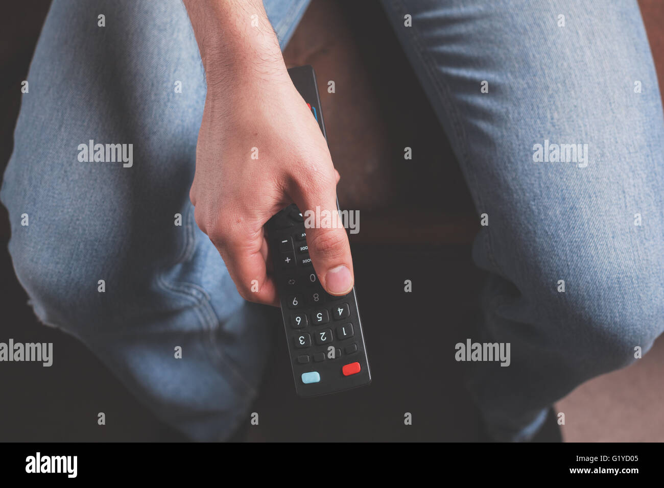 A male hand is holding and pointing a remote control Stock Photo - Alamy