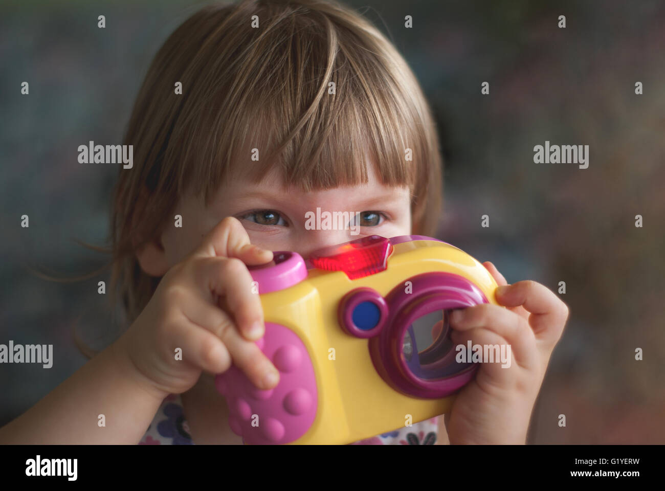 Little girl playing with toy camera, taking a photo Stock Photo - Alamy