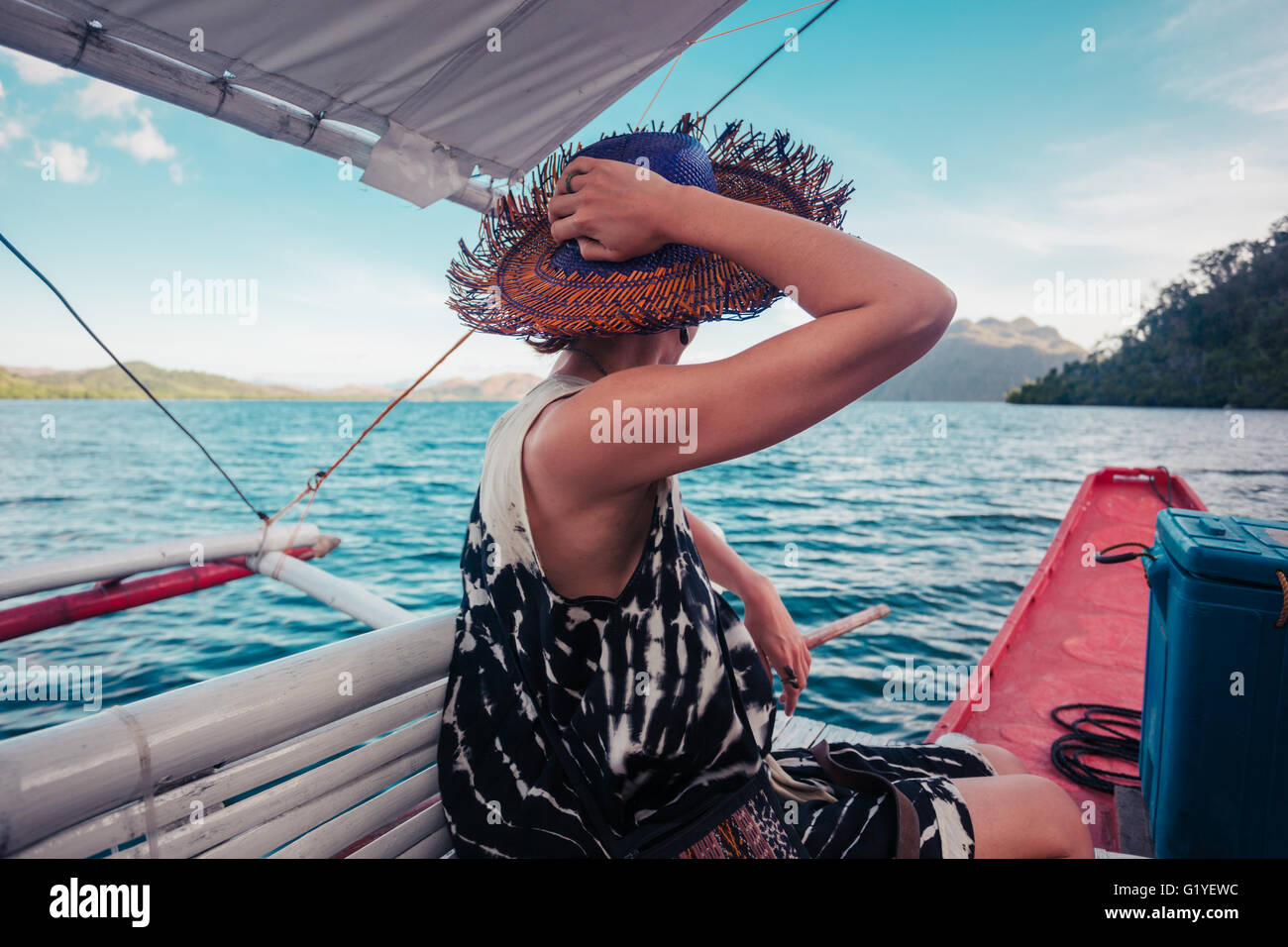 A young woman wearing a hat is on a boat in the tropics Stock Photo - Alamy