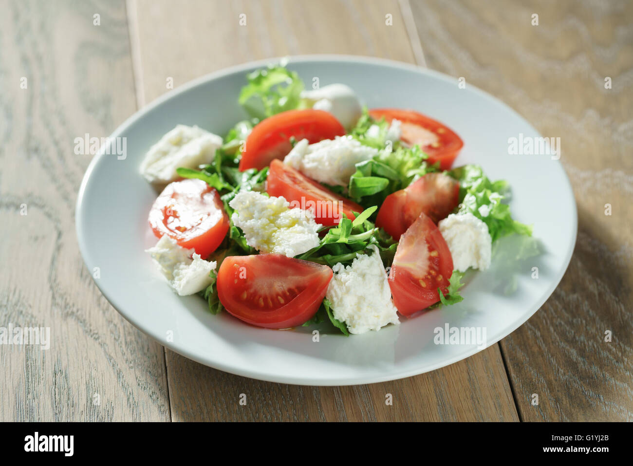 fresh summer salad with tomatoes, rucola, frillis and mozzarella in ...