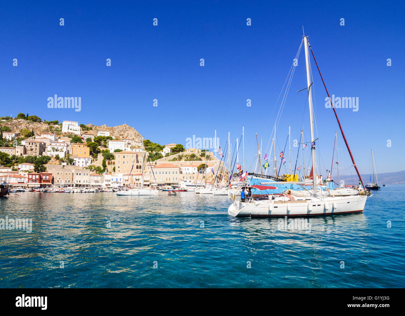 A yacht leaves the harbour of Hydra Town, Hydra Island, Greece Stock ...