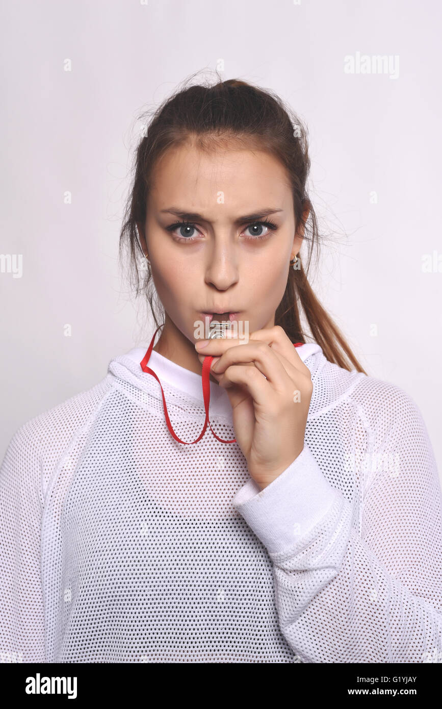 Portrait of beautiful and athlete young woman with whistle. Isolated ...