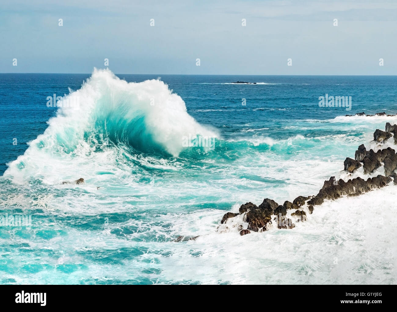 Ocean wave splashing sea water on rocky shore line, with water foam and ...