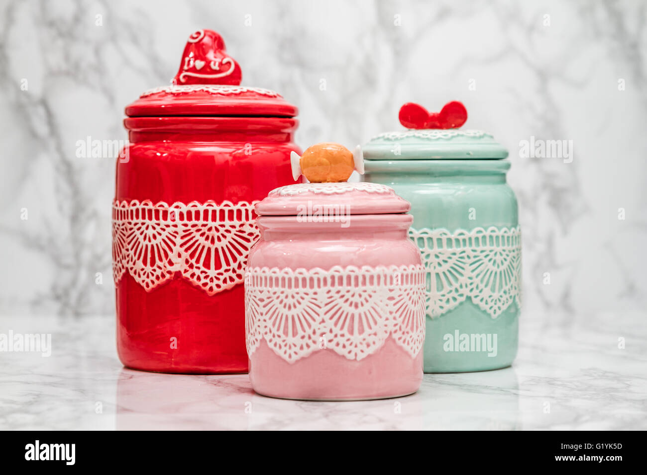 Colorful ceramic round jars with lace patterns on white marble ...