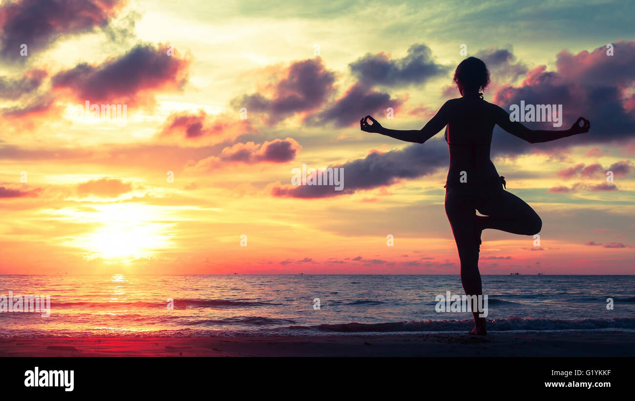 Yoga silhouette at surreal bloody sunset on the sea shore. Calm and ...