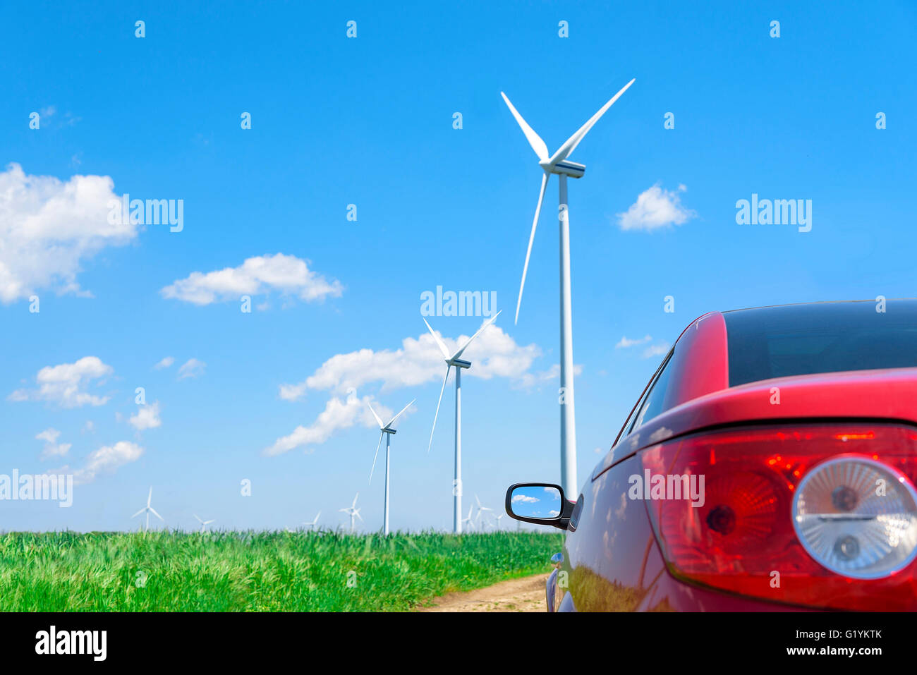 Red car and wind turbines generating electricity Stock Photo - Alamy