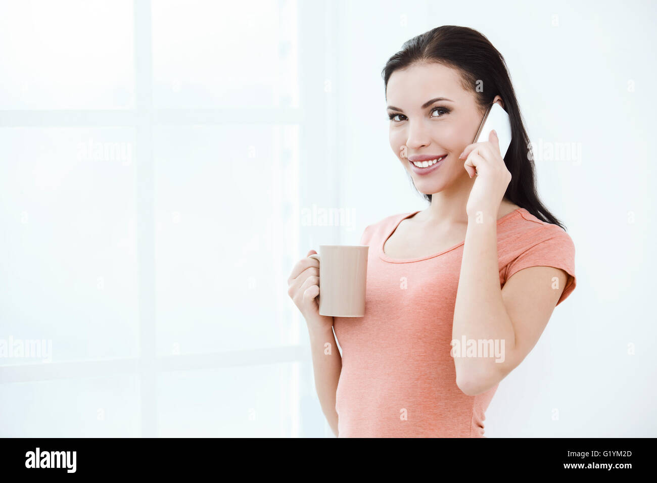 Beautiful young woman near window Stock Photo - Alamy