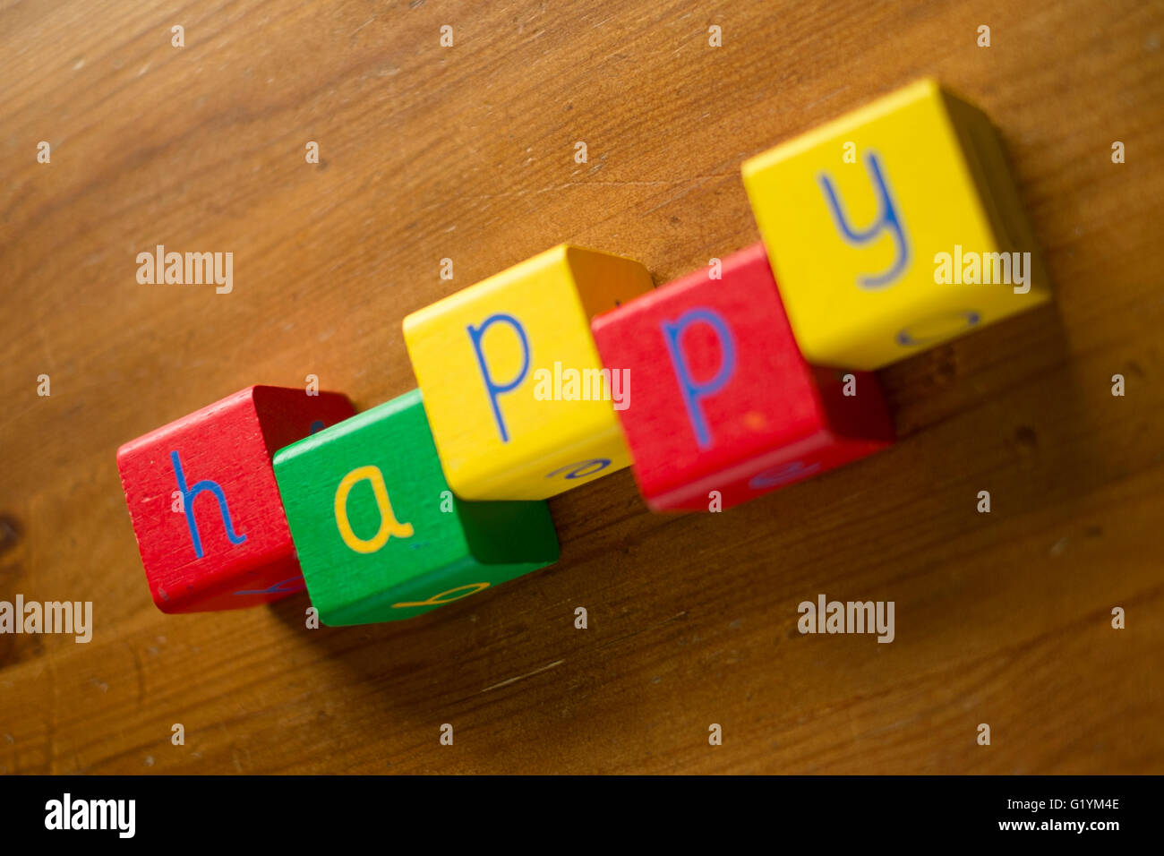 Colorful wooden blocks spelling the word/letters HAPPY Stock Photo - Alamy