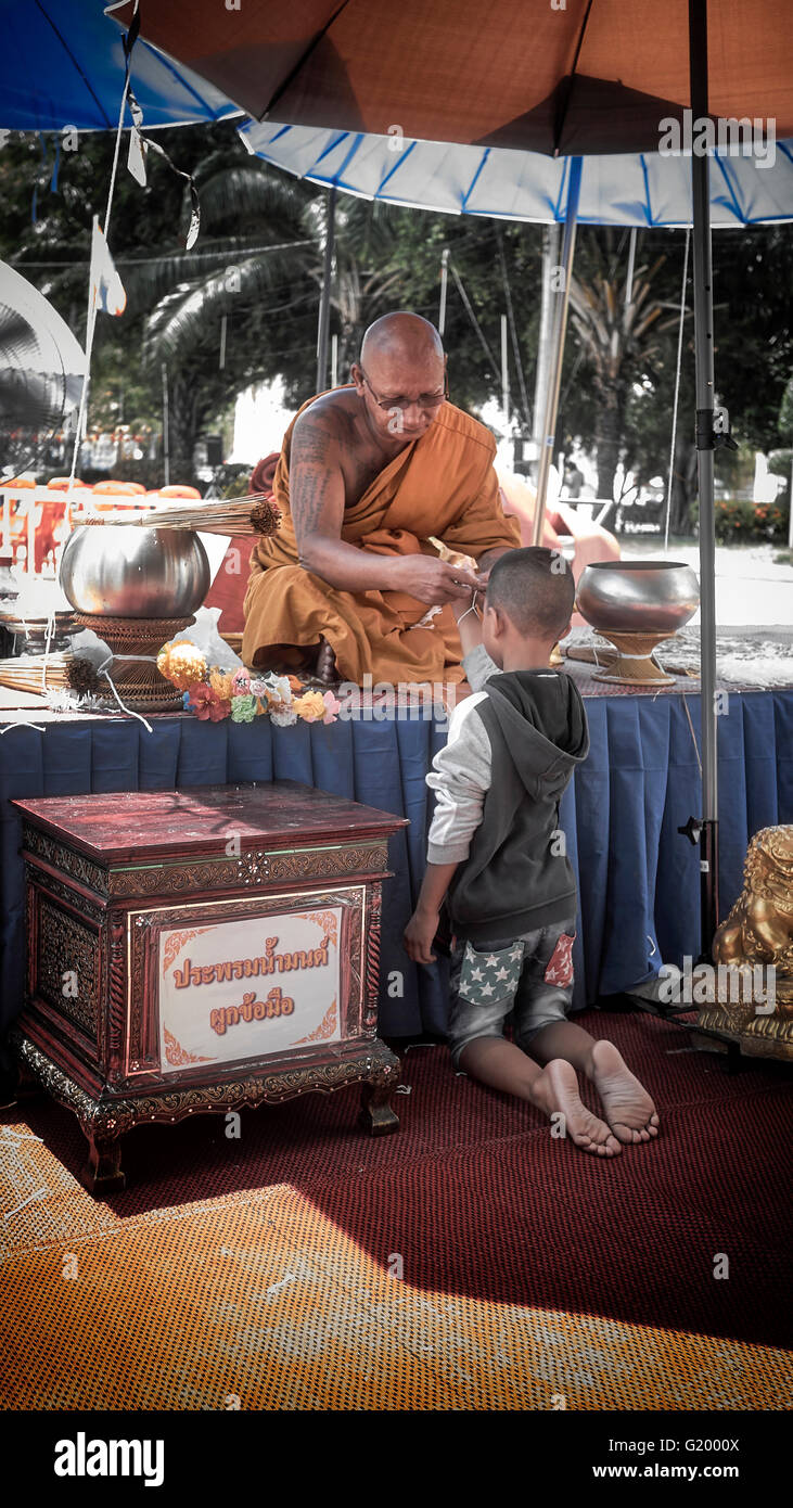 Monk blessing. Young Buddhist boy receiving a monks blessing. Thailand ...