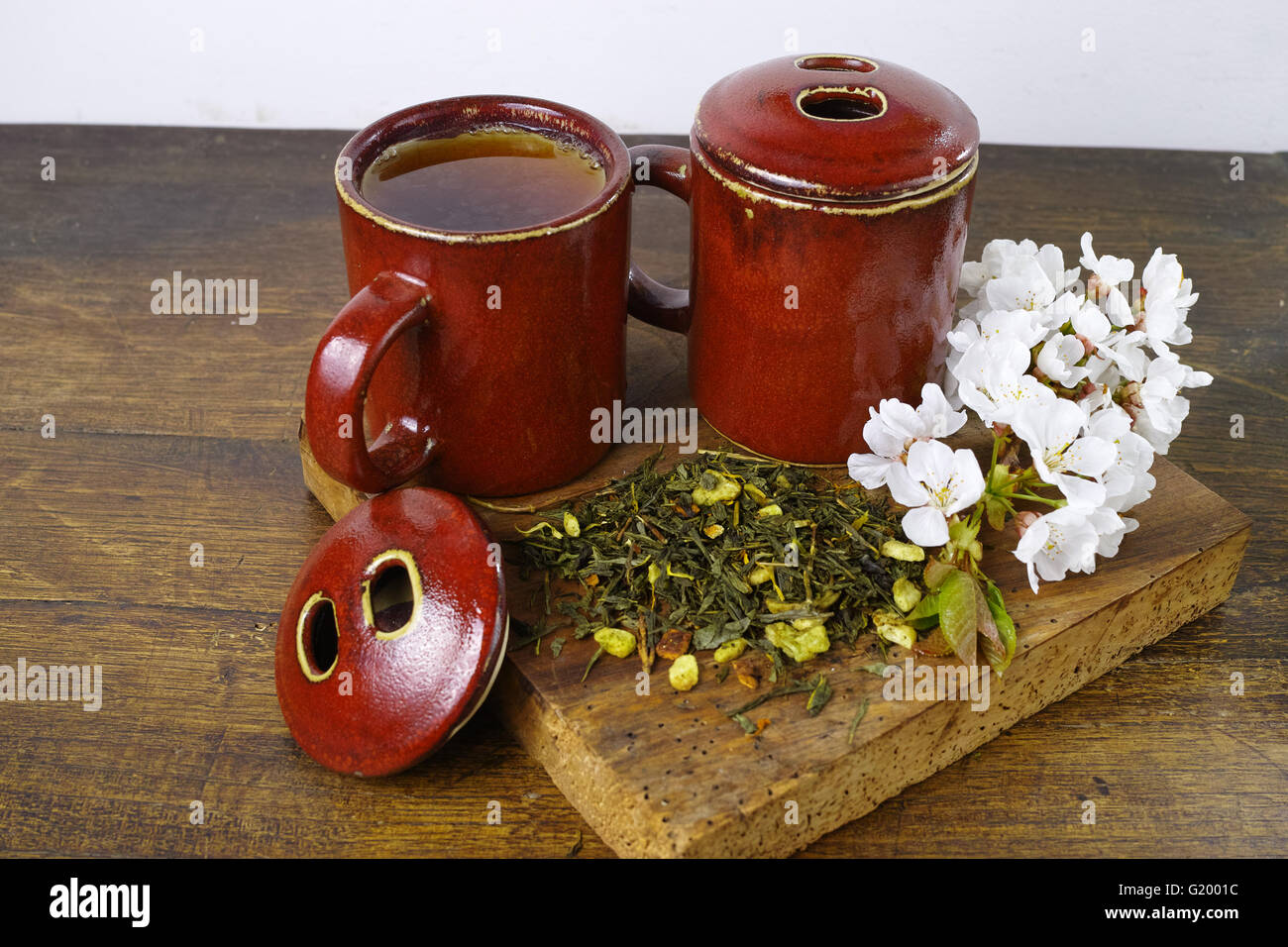 Japan's tea cups with green tea on wooden plank and sakura flowers on ...