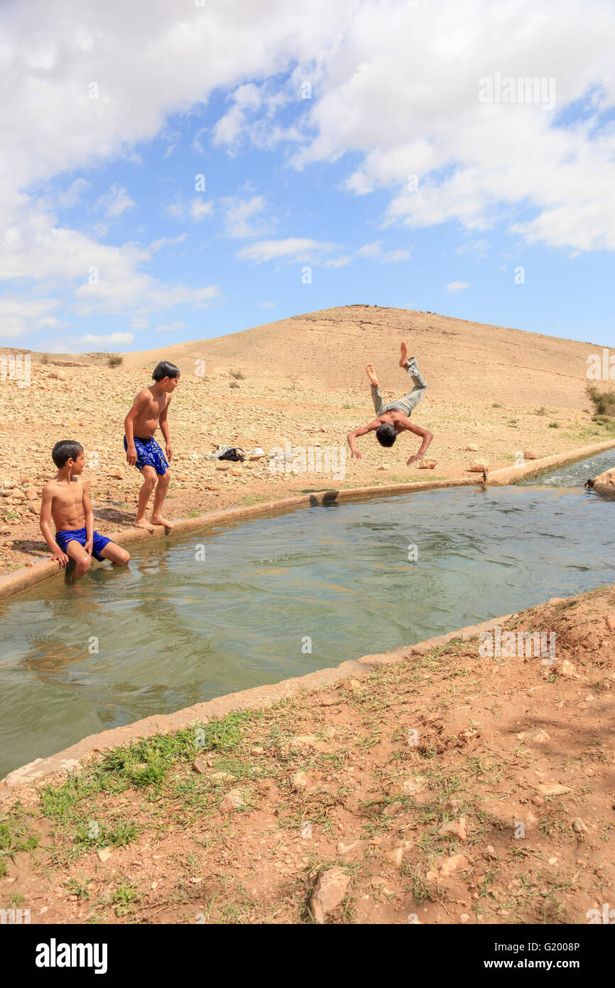 Palestinian Bedouin children playing in the fresh running water during ...