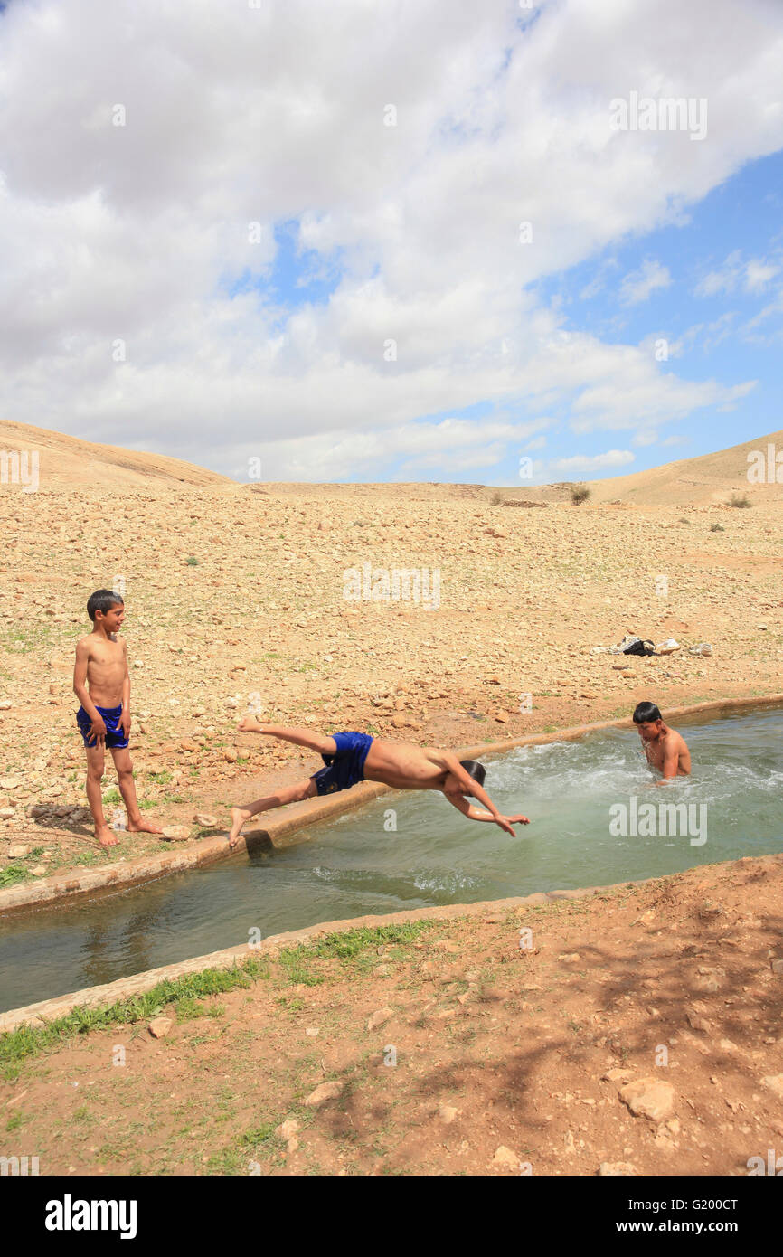 Palestinian Bedouin children playing in the fresh running water during ...
