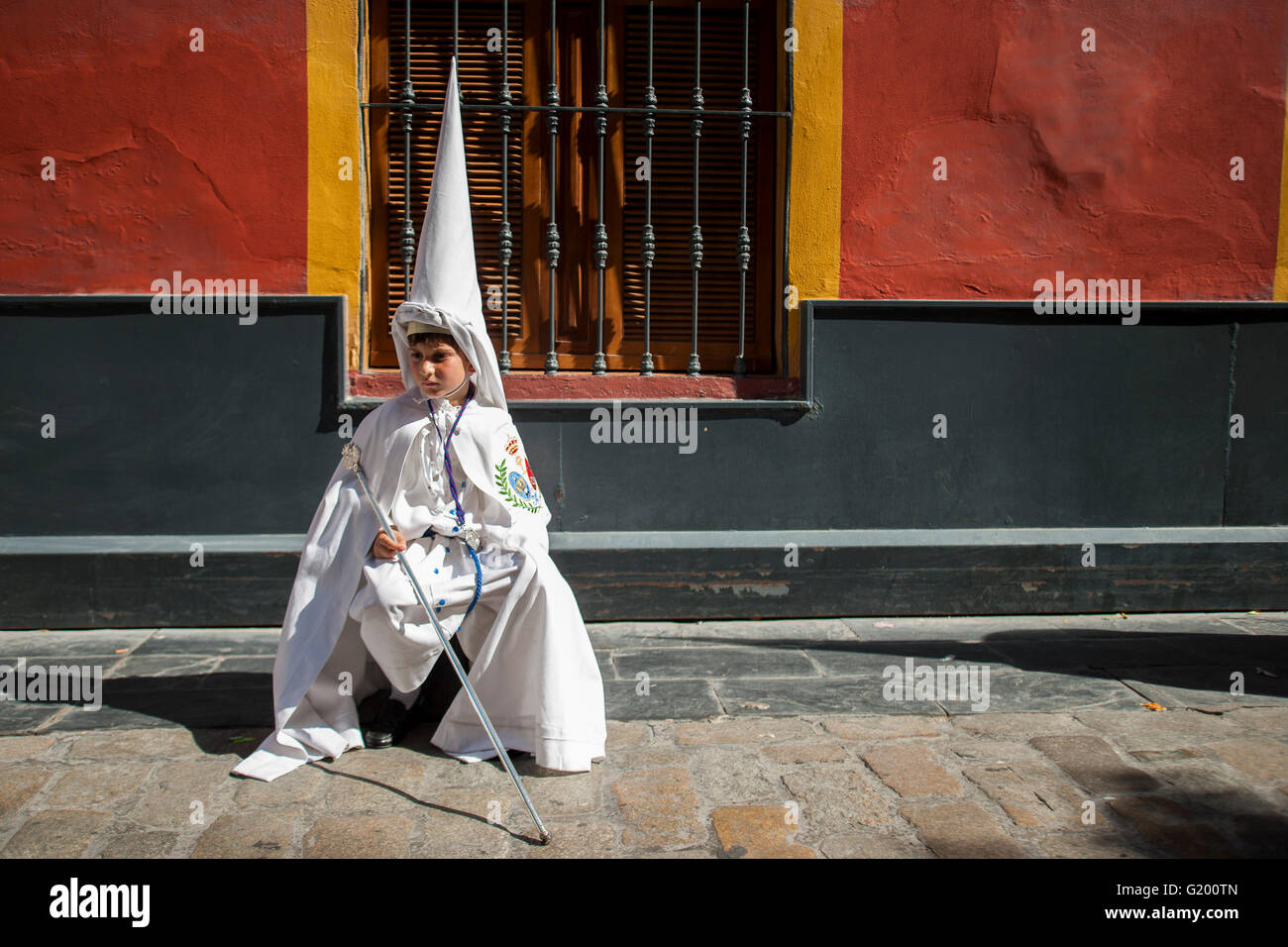 A "nazareno" of the Brotherhood called "La Paz" waits sitting during ...