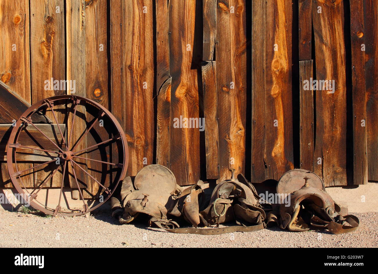 Wild West – Old wild west wooden barn with horse saddle and wagon wheel ...