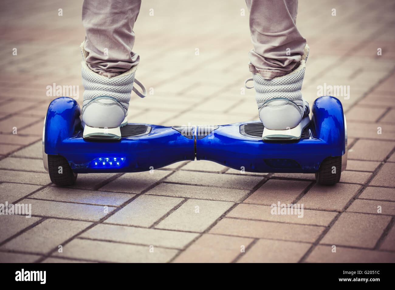 Person riding a modern blue electric mini segway or hover board ...