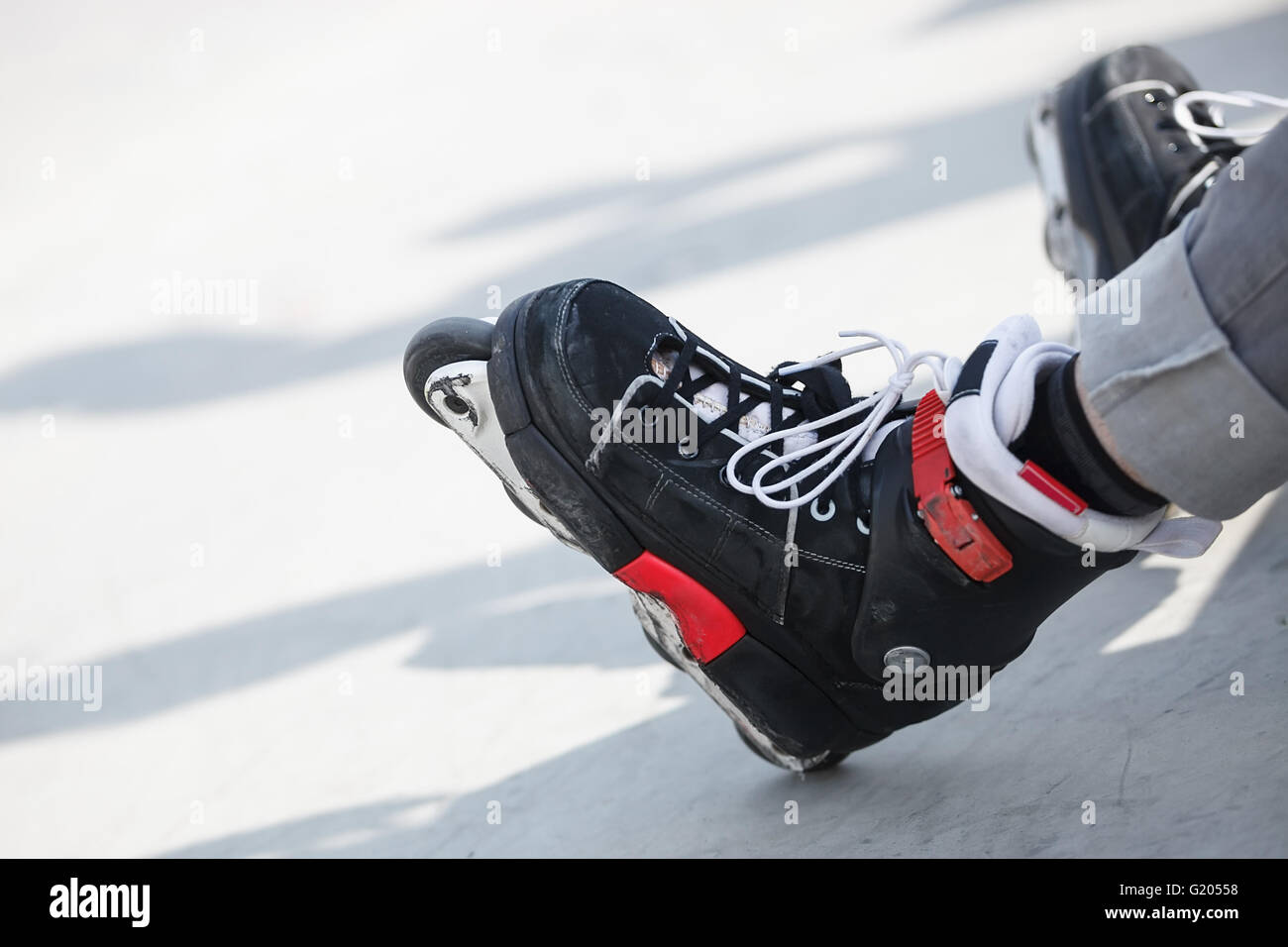 Feet of rollerblader wearing aggressive inline skates sitting on a ...