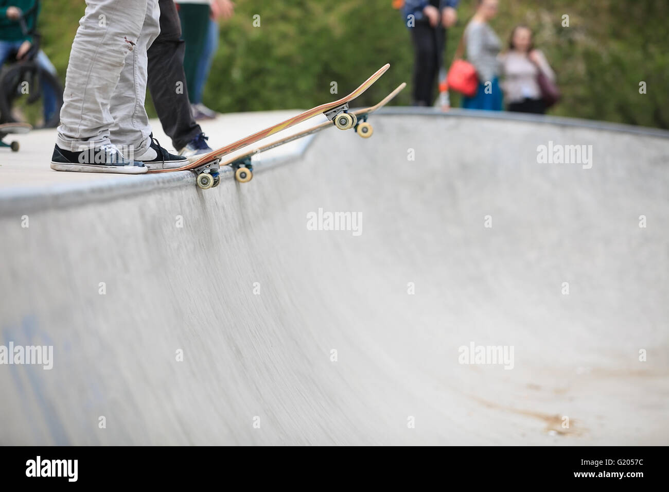 Skateboarder standing on a ramp in skate park ready to ride skate board ...