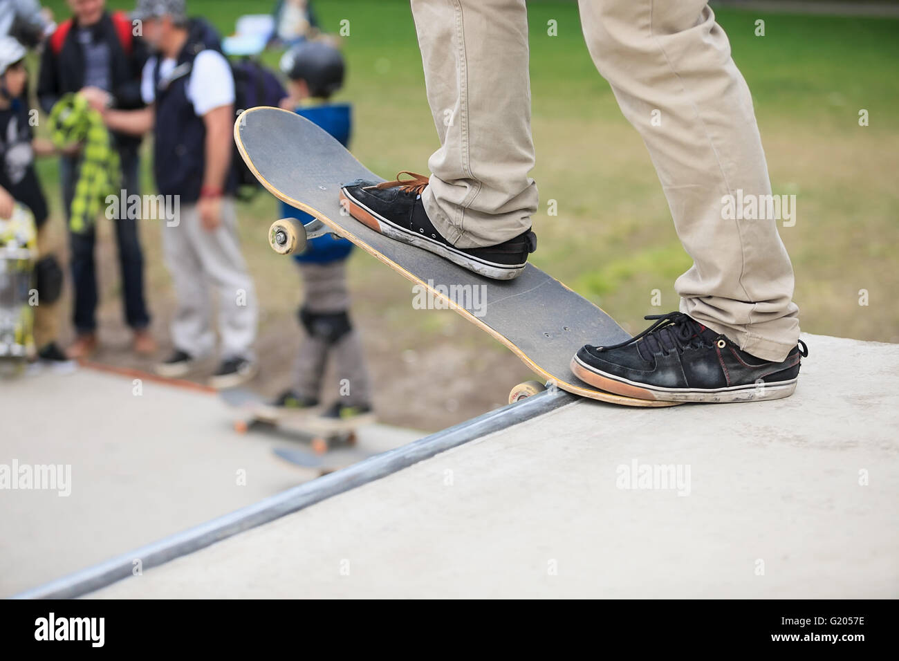 Skateboarder standing on a ramp in skate park ready to ride skate board ...