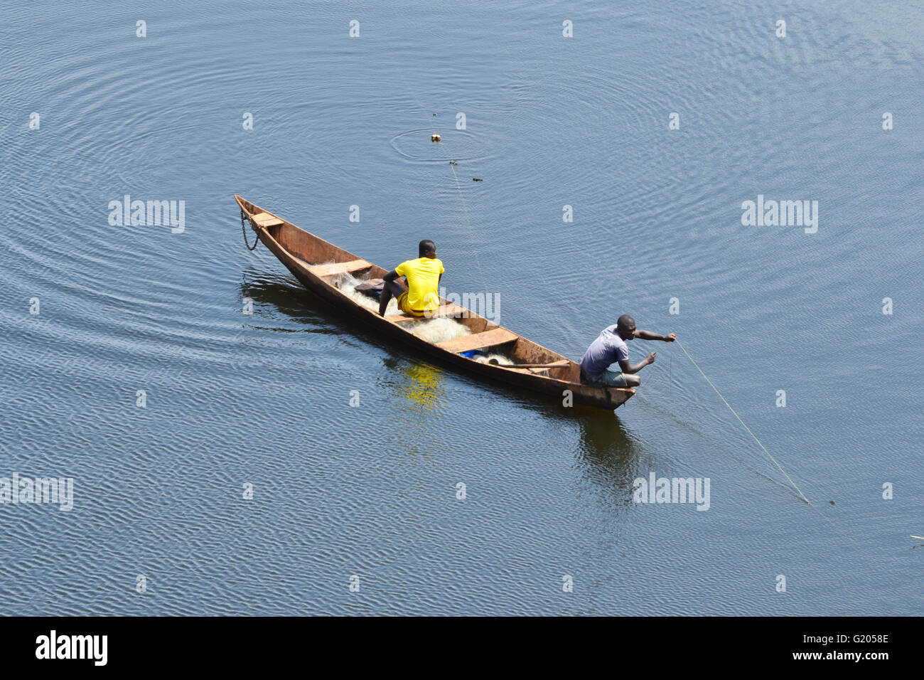Two men cast a fishing net in Abidjan's lagoon, Ivory Coast Stock Photo ...
