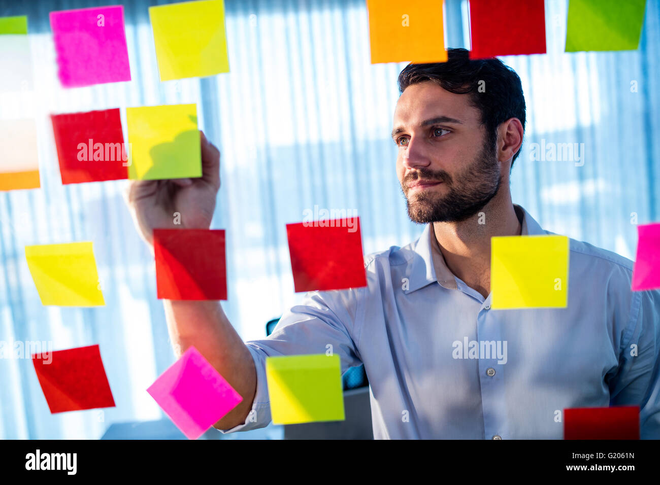 Businessman writing on post it Stock Photo - Alamy