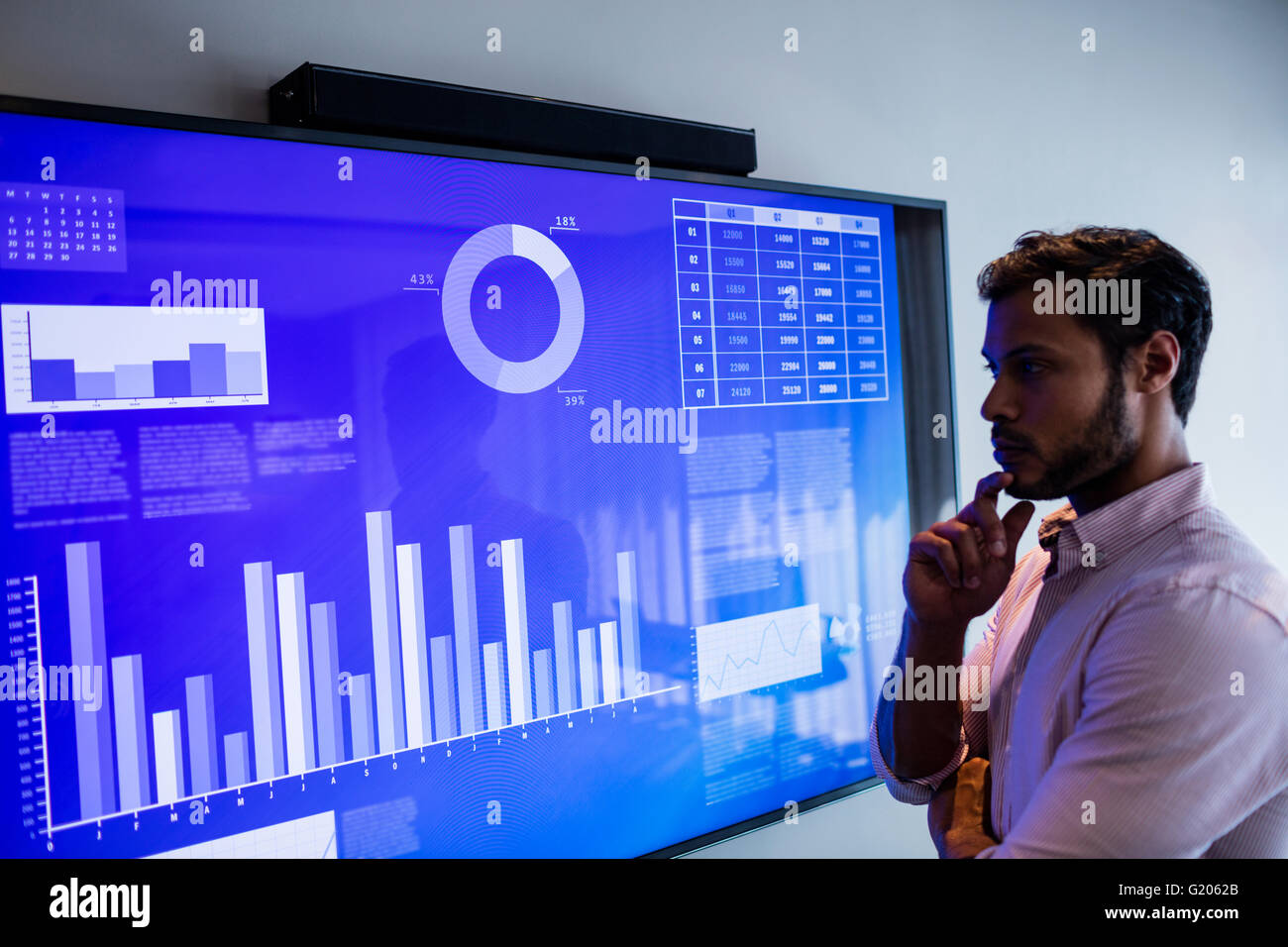 Serious man looking at graph on a screen Stock Photo - Alamy