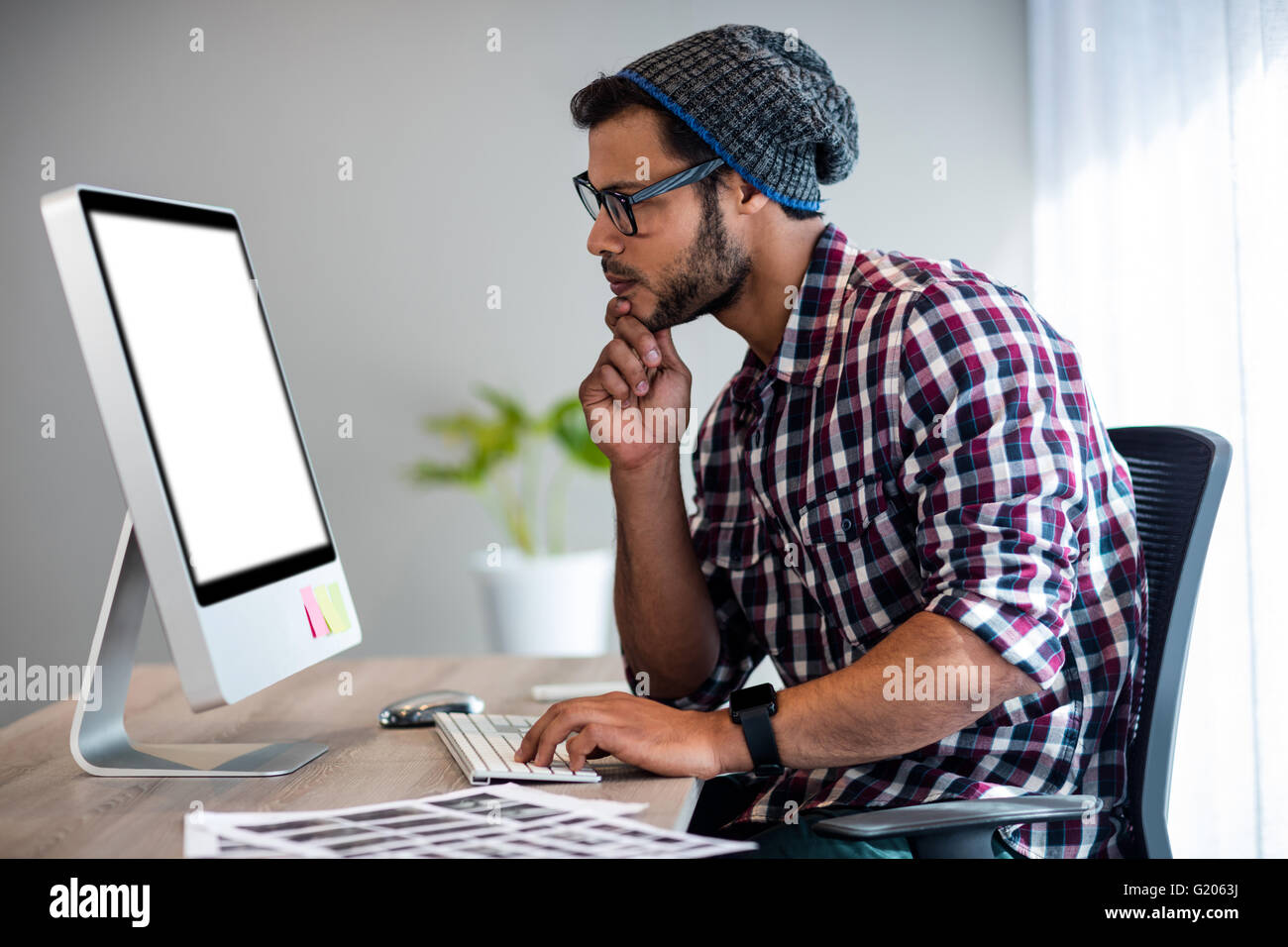Serious casual man working at computer desk Stock Photo - Alamy