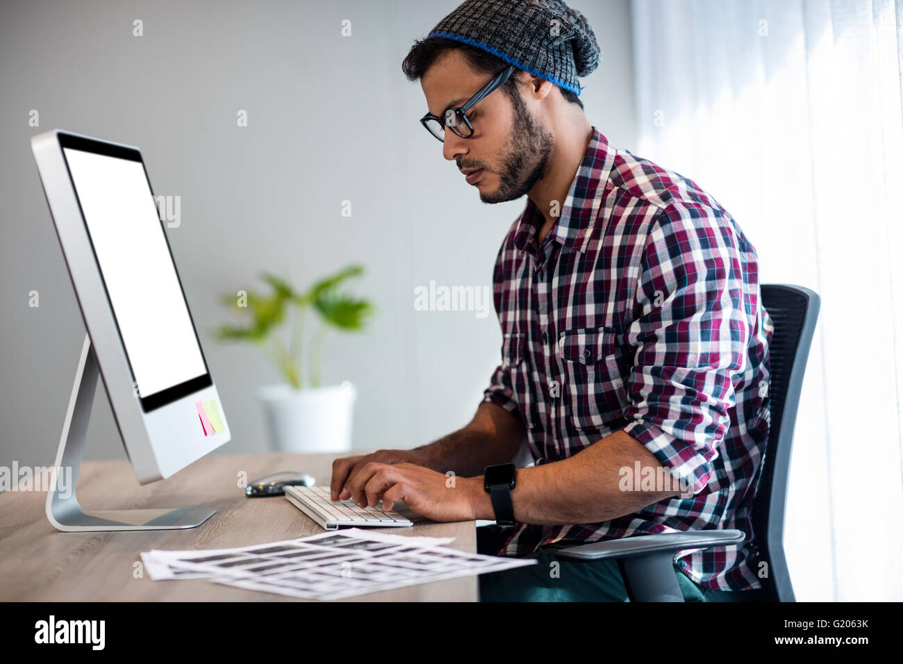 Serious casual man working at computer desk Stock Photo - Alamy