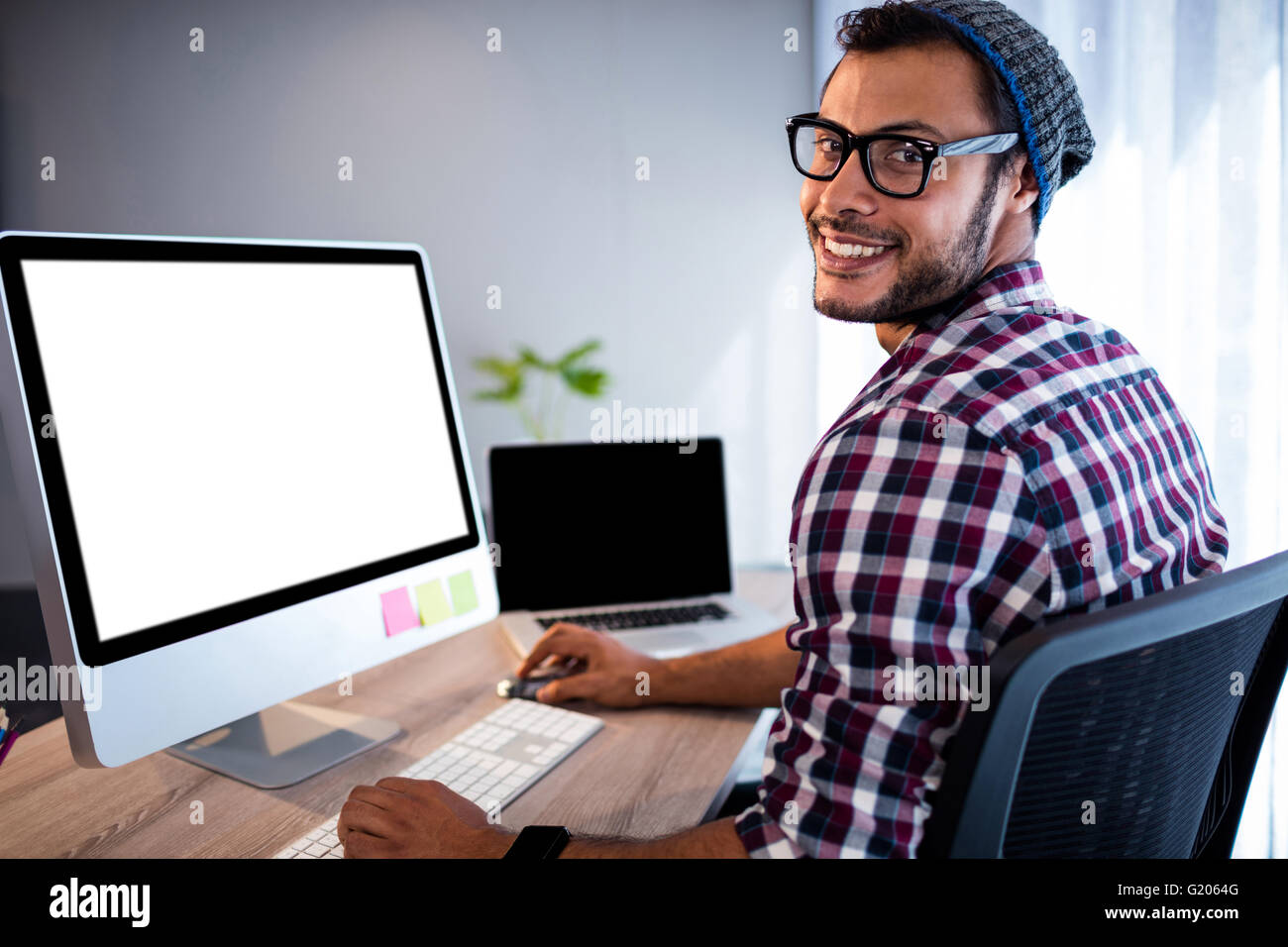 Portrait of casual man working at computer desk Stock Photo - Alamy