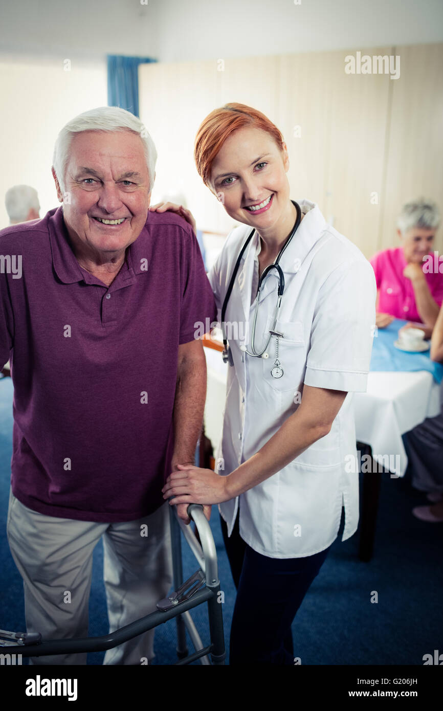 Nurse assisting a senior using a walker Stock Photo - Alamy