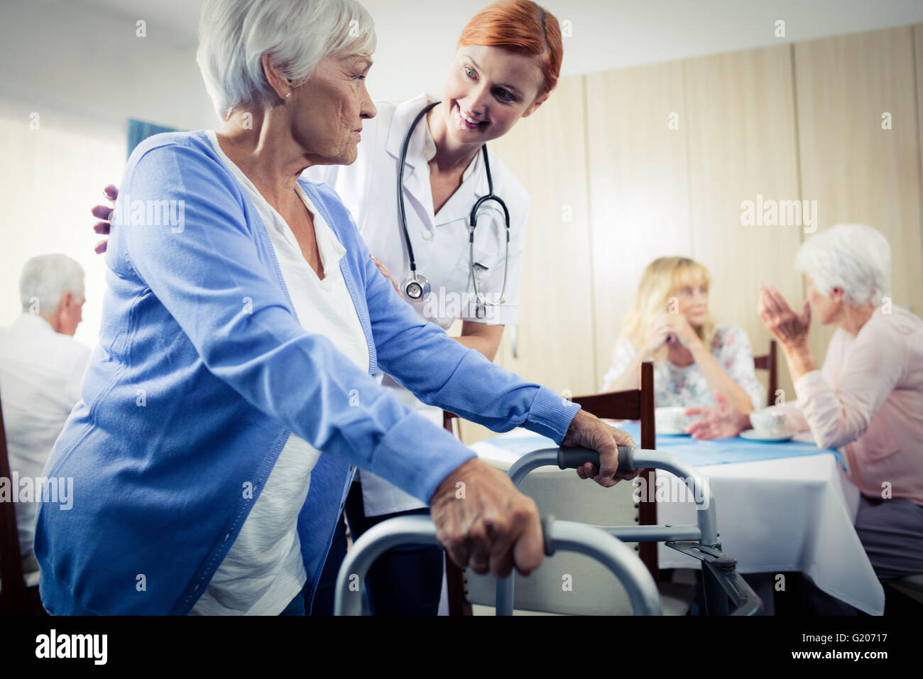 Nurse assisting a senior using a walker Stock Photo - Alamy
