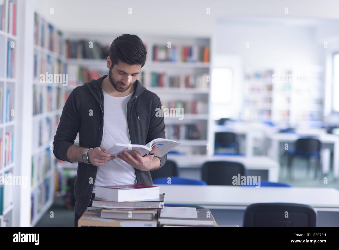 Portrait of happy student while reading book in school library. Study ...