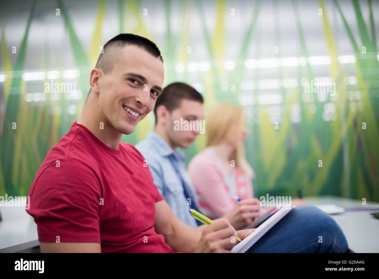 male student taking notes in classroom. business education concept ...