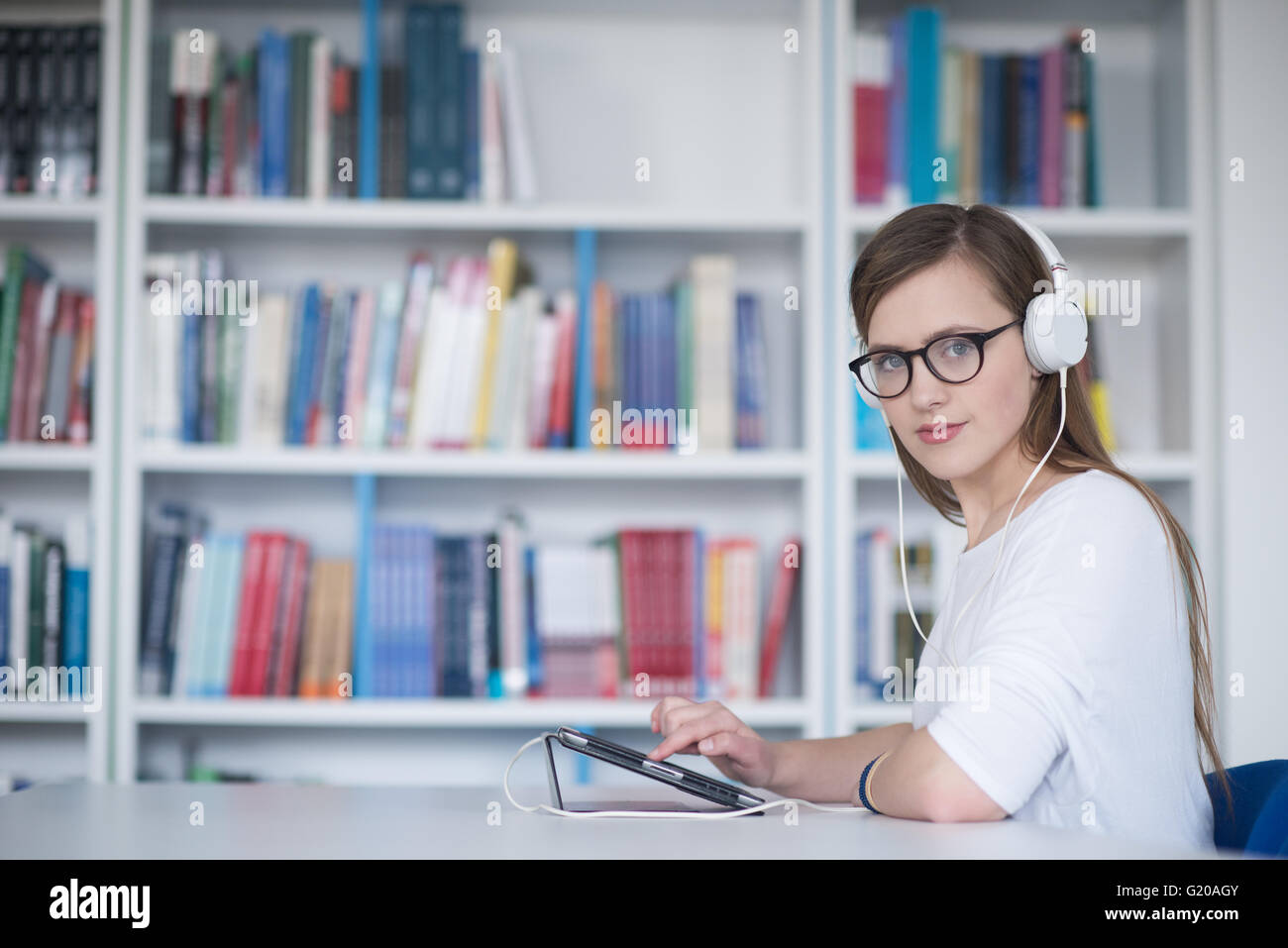 female student study in school library, using tablet and searching for ...