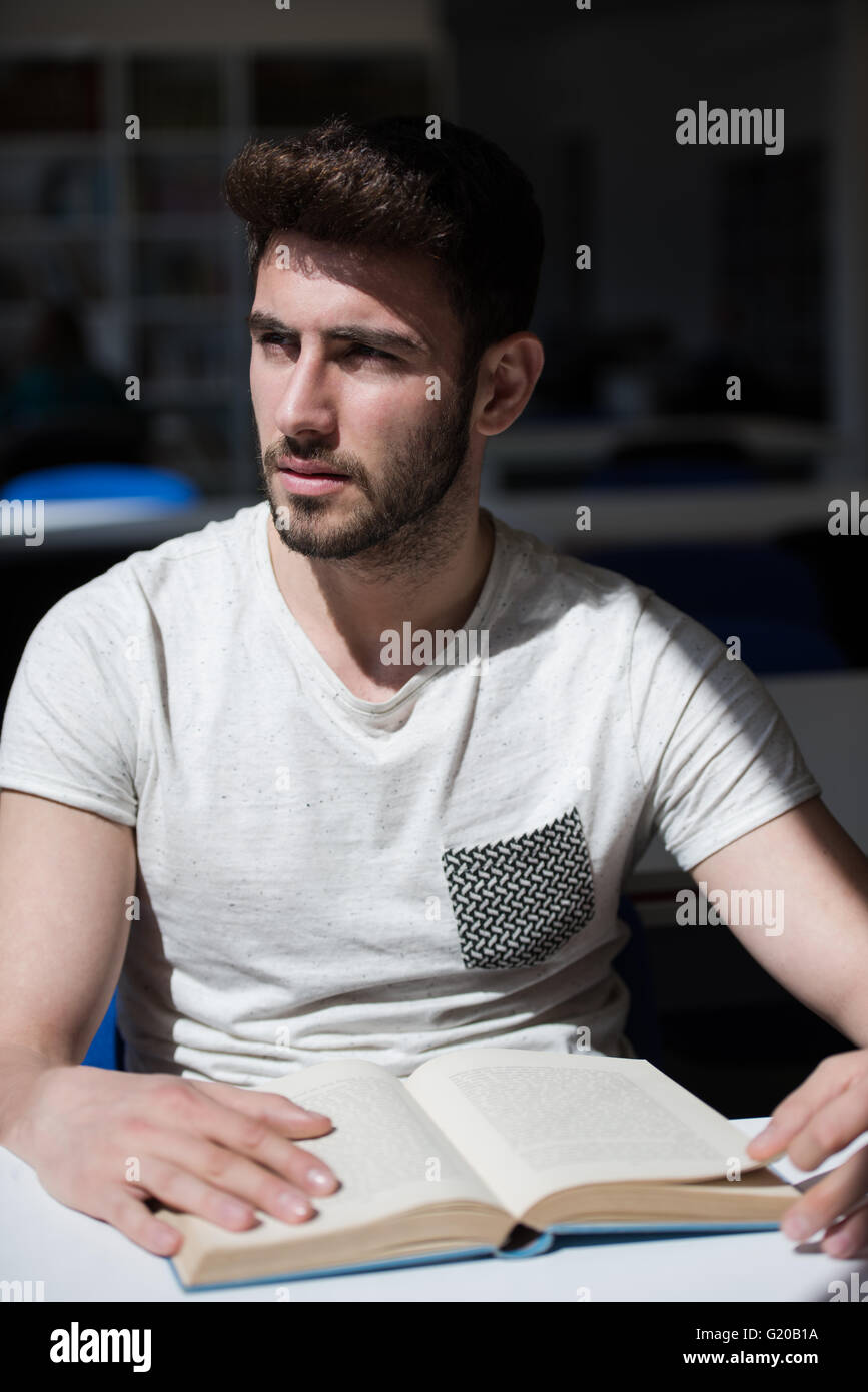 Student reading book in school library. Study lessons for exam. Hard ...