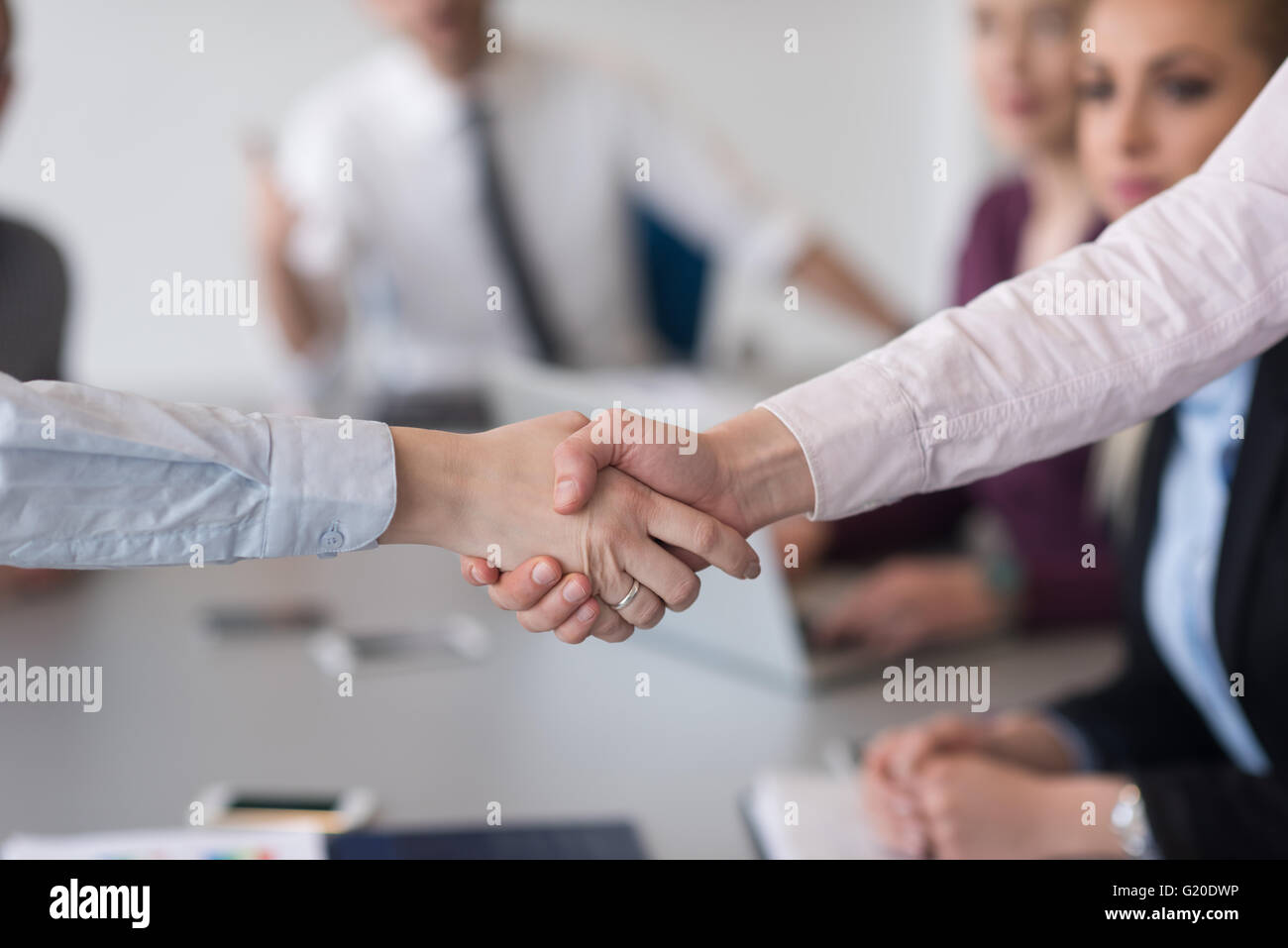 businesswomans handshake on team meeting with group of people blured in ...
