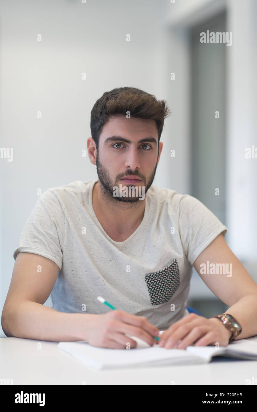male student taking notes in classroom. business education concept ...