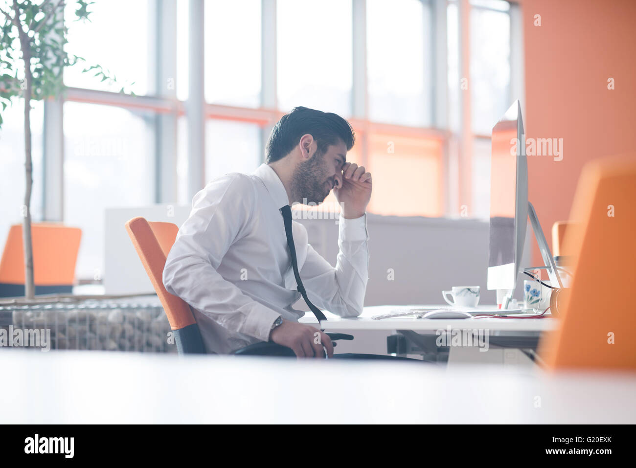 frustrated young business man working on desktop computer at modern ...