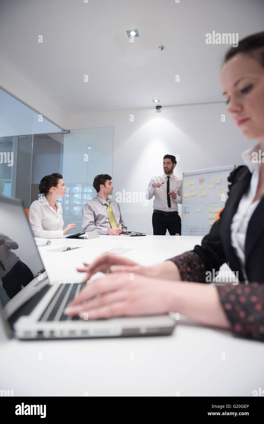 young business woman on meeting usineg laptop computer, blured group of ...