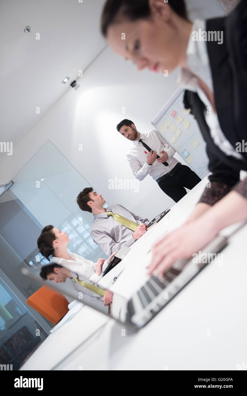 young business woman on meeting usineg laptop computer, blured group of ...