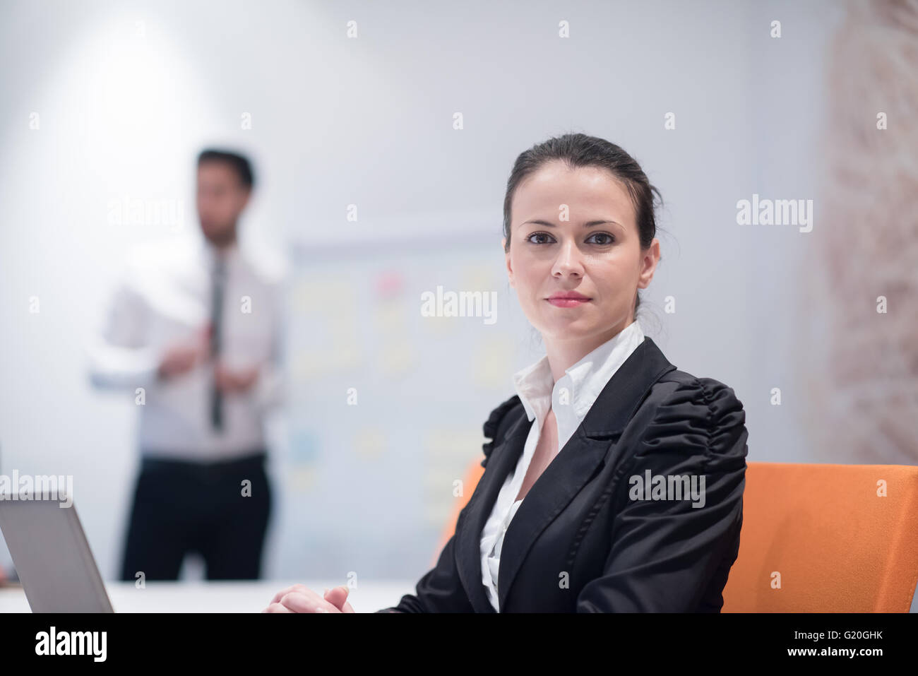 young business woman on meeting usineg laptop computer, blured group of ...