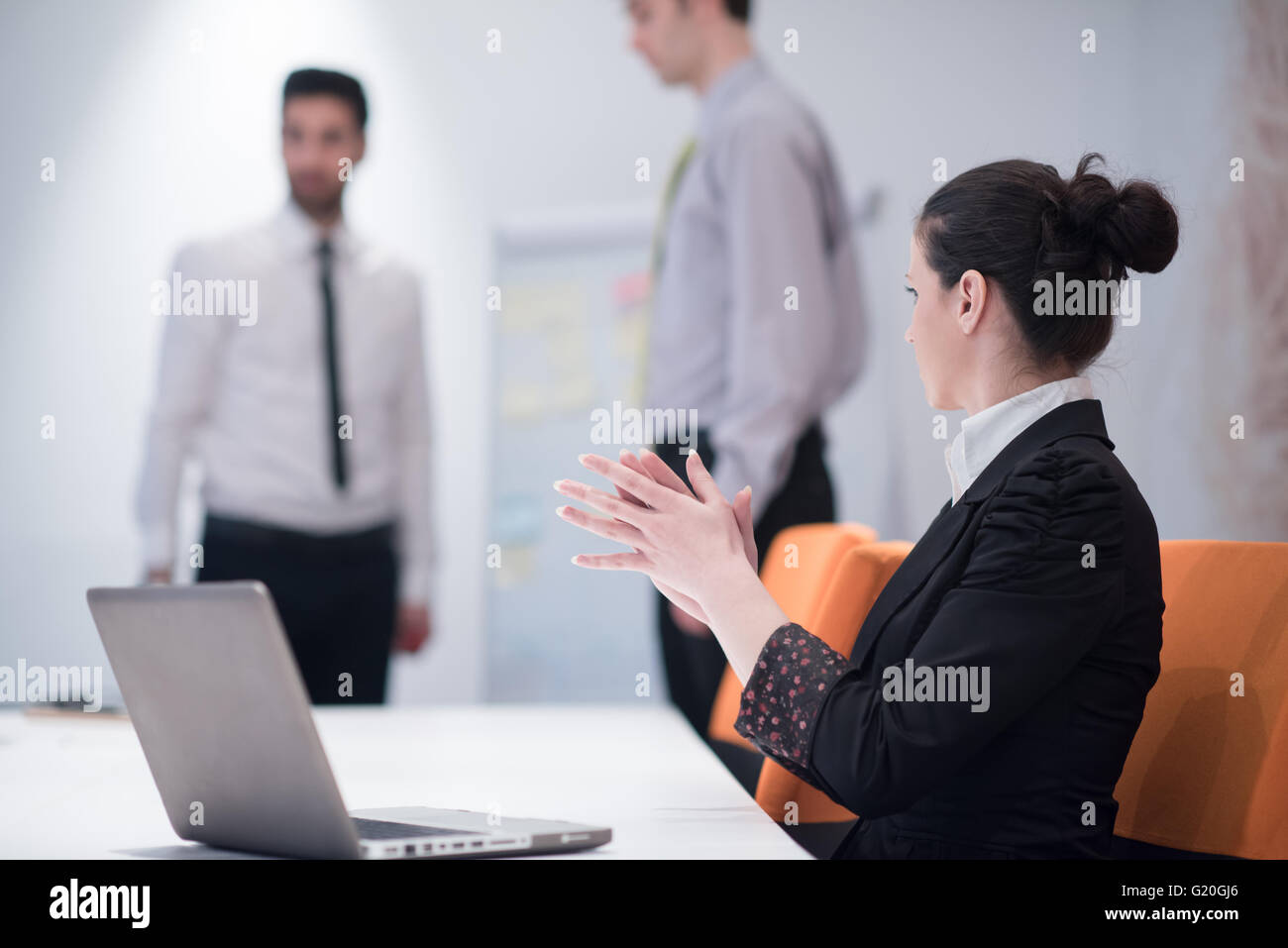 young business woman on meeting usineg laptop computer, blured group of ...