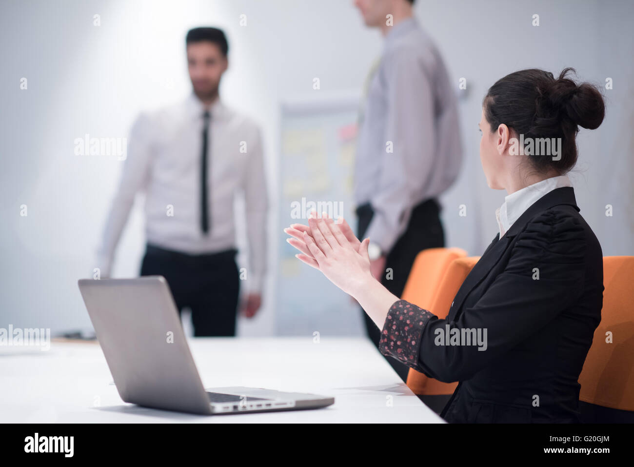 young business woman on meeting usineg laptop computer, blured group of ...