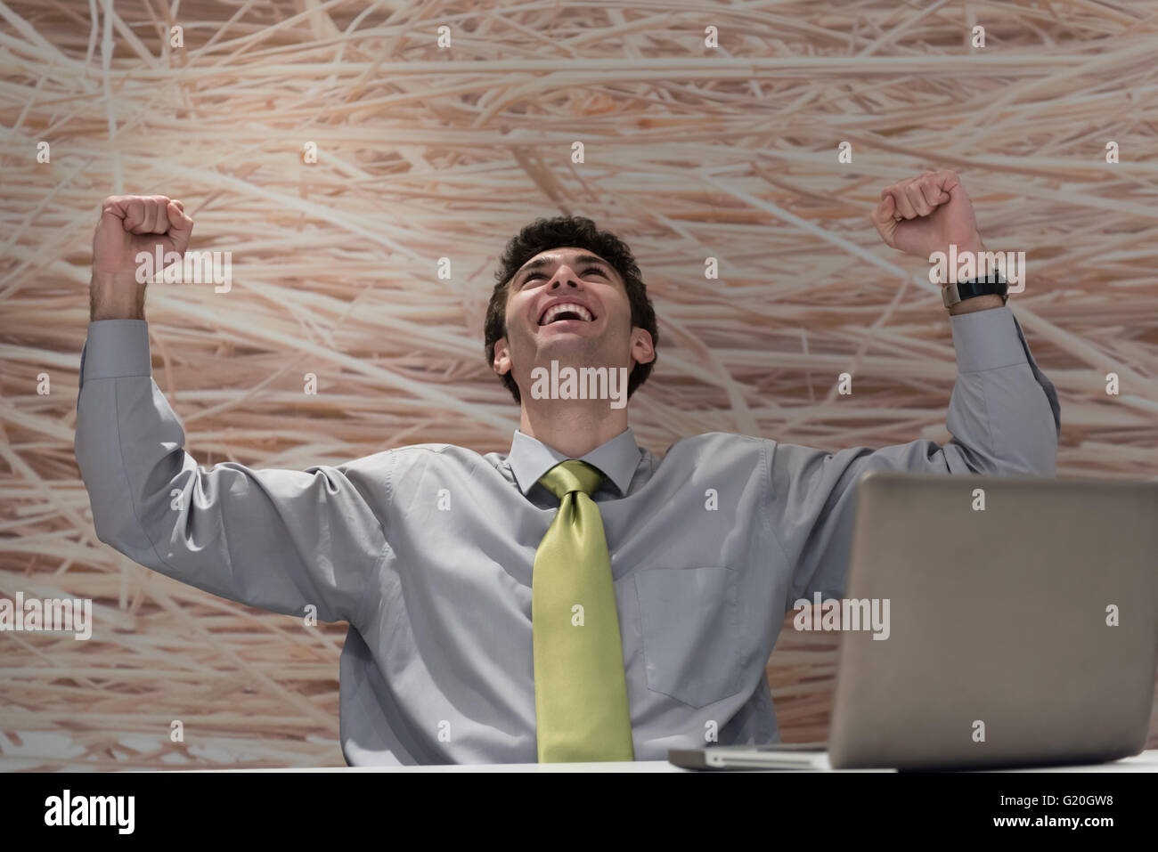 happy young business man working on laptop computer at his desk in ...