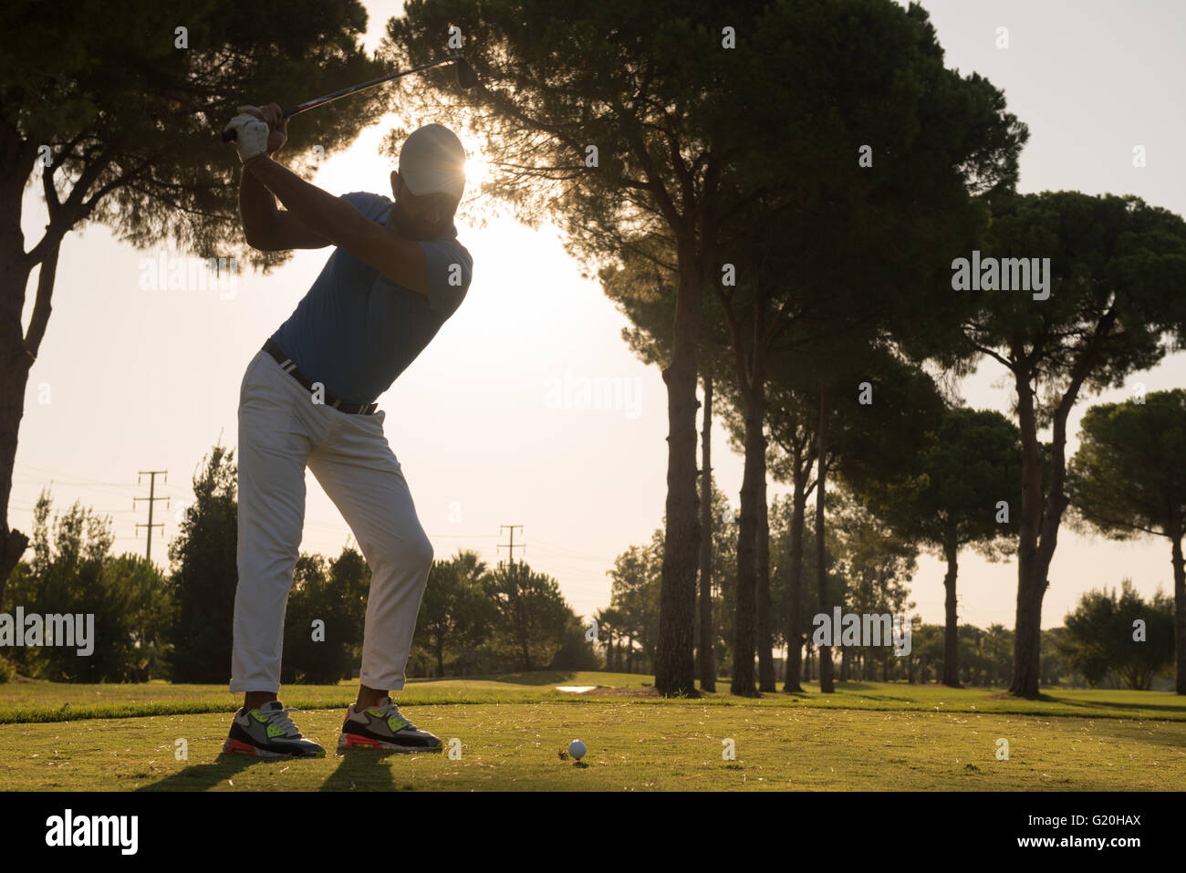 golf player hitting shot with club on course at beautiful morning with ...